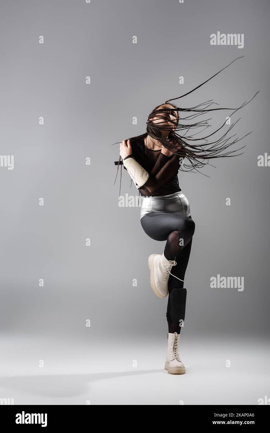 full length of woman with dreadlocks posing in futuristic attire on ...