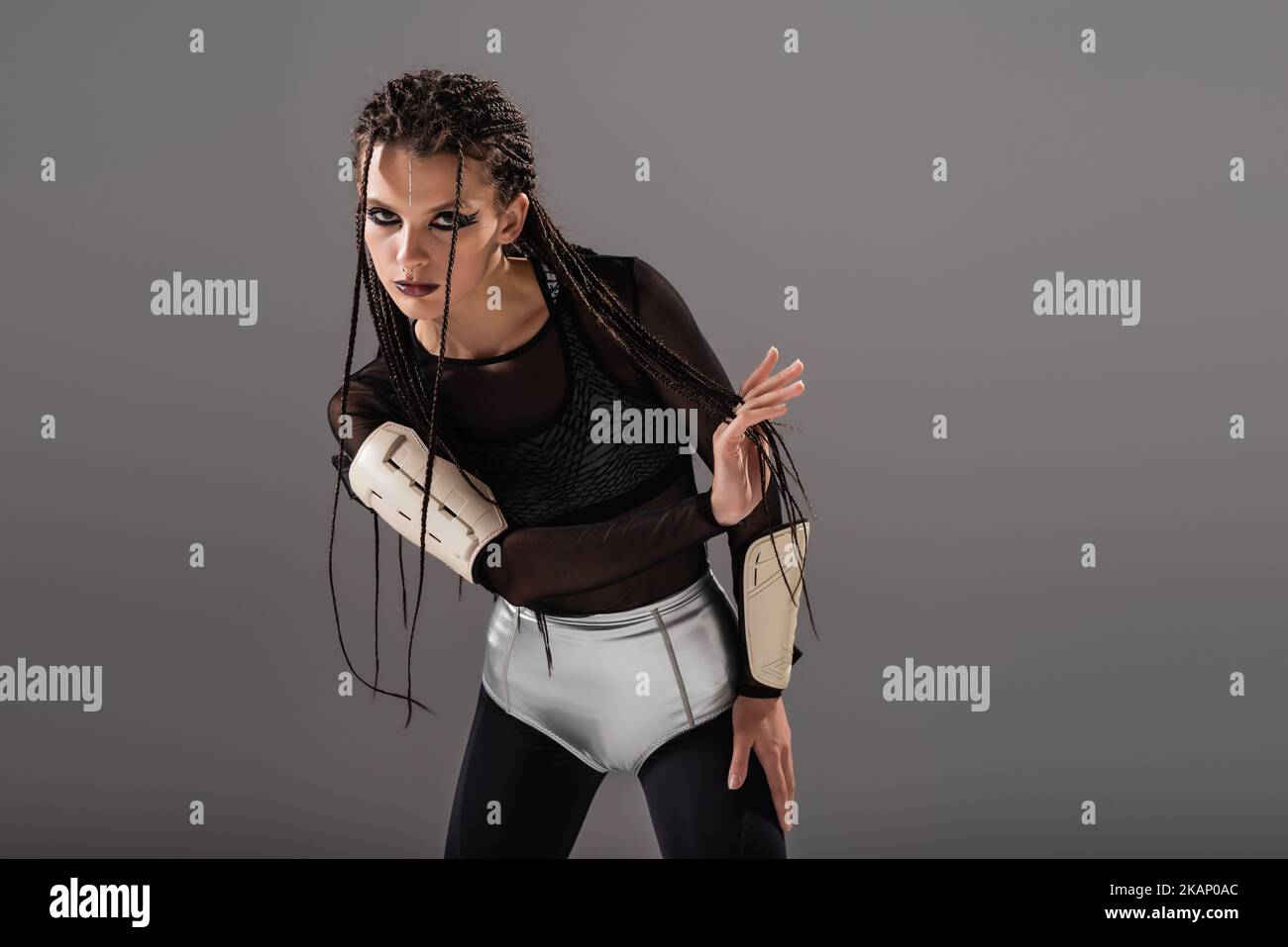 futuristic woman with dreadlocks posing in tight jumpsuit and silver ...