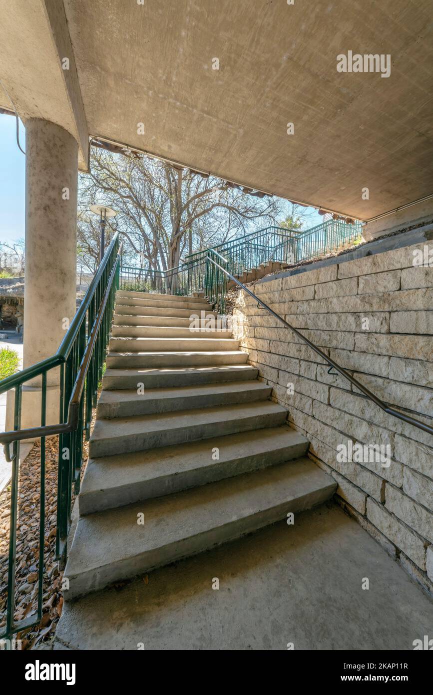 San Antonio, Texas- Staircase under a bridge with stone walls. Concrete ...