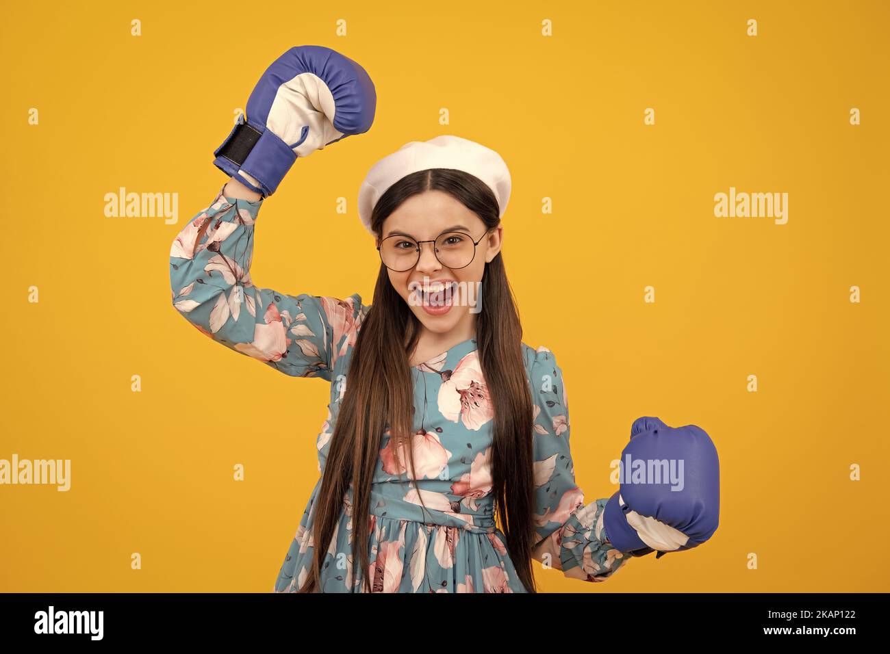 Excited face. Young child girl using boxing gloves with funny face ...