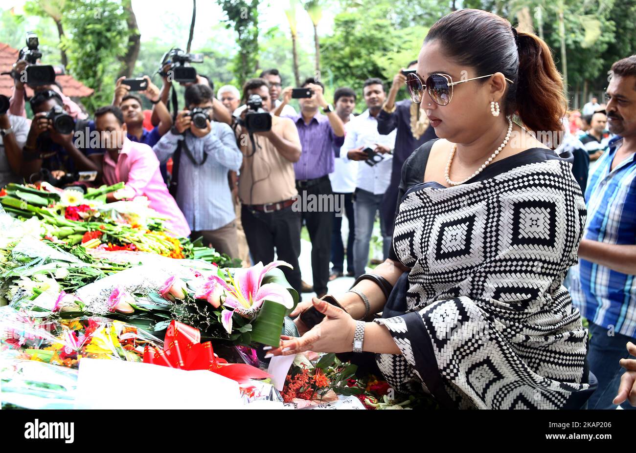 A woman visits a memorial at the former location of Holey Artisan ...