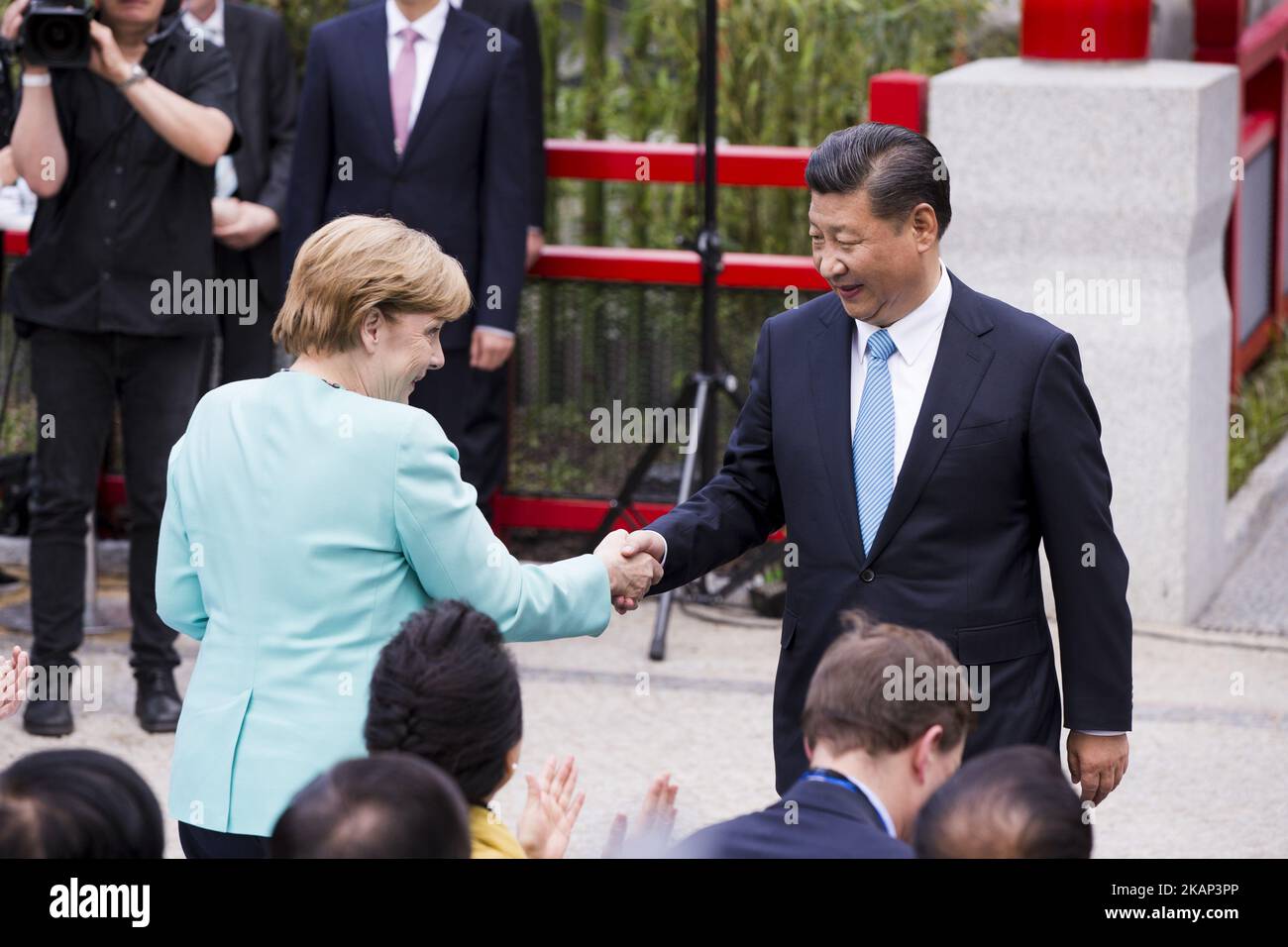 China's President Xi Jinping and German Chancellor Angela Merkel shake ...