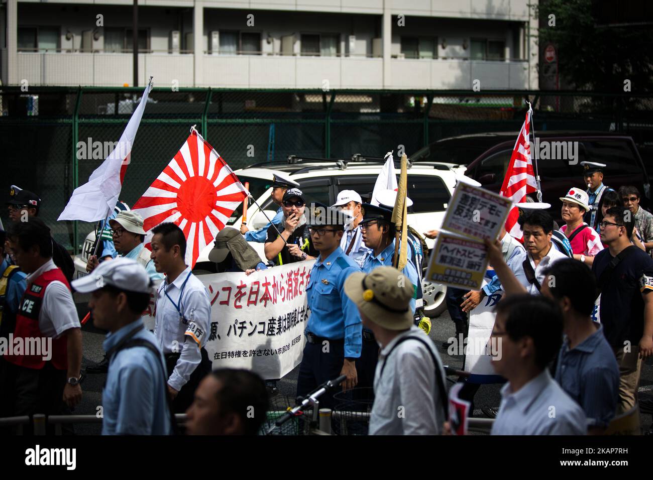 Japanese nationalists holding Japanese maritime flags, escorted by ...