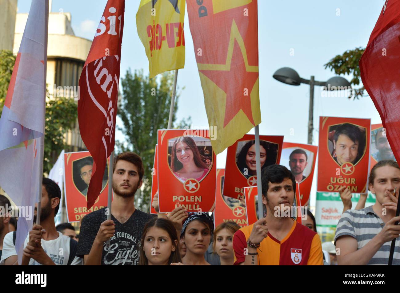 People hold flags and portraits of victims during a commemoration to ...
