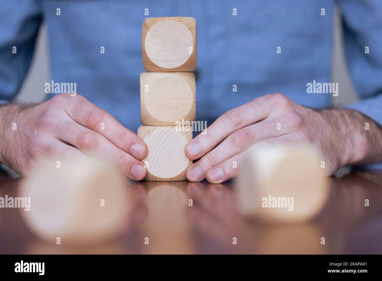 Close up of a business person arranging large wooden blocks. Business ...