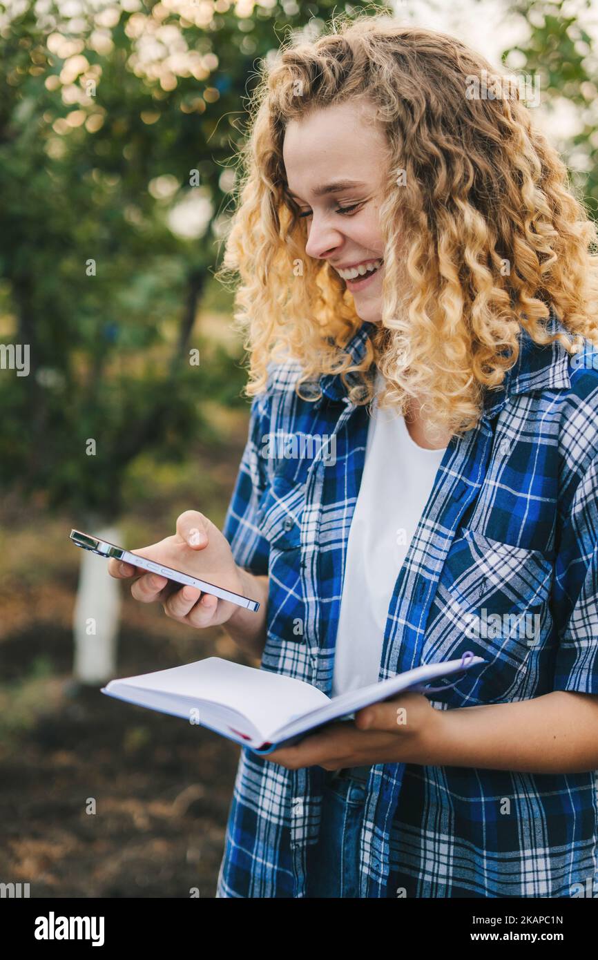 Smart farming. Woman with curly hair agronomist farmer with a notebook ...