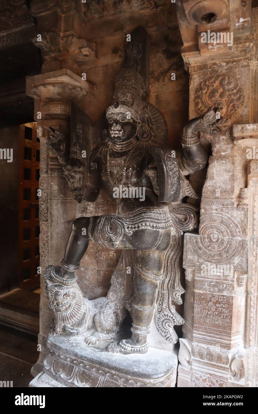 A black statue on the wall of the ancient Tanjore Brihadeeswarar temple ...