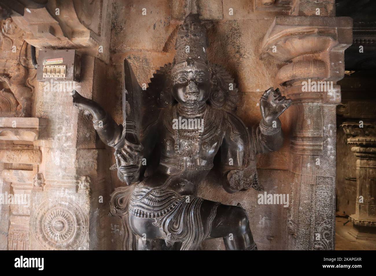 A black statue on the wall of the ancient Tanjore Brihadeeswarar temple ...