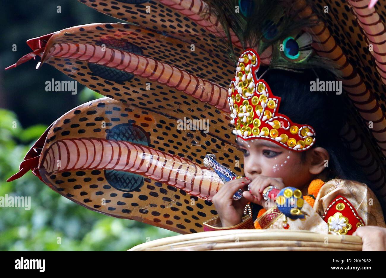 A couple poses as Sri Krishna and Radha on a peacock like float in a ...