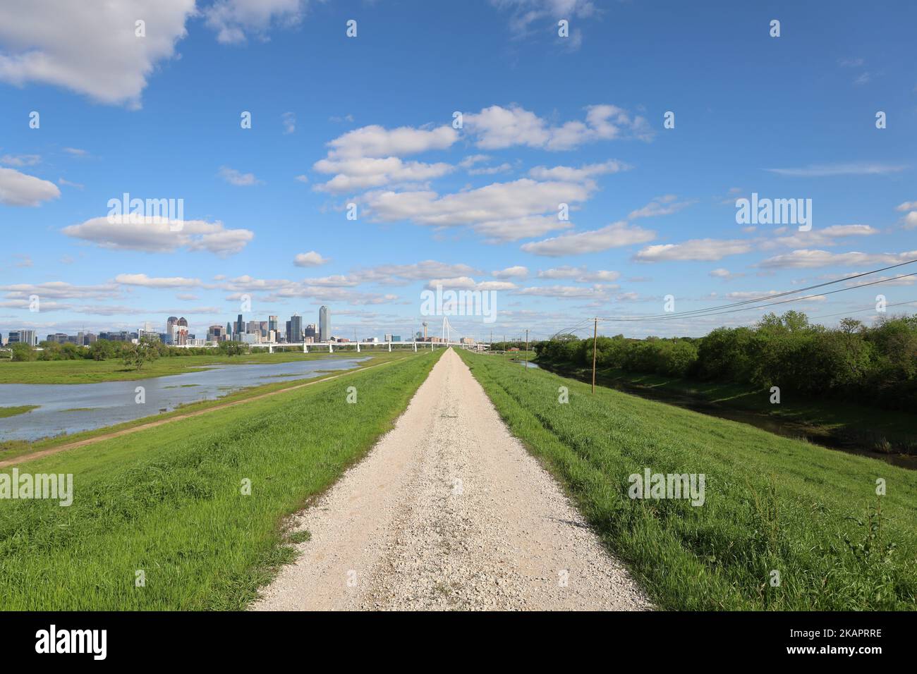 A straight dirt road with green grasses near the river Stock Photo - Alamy