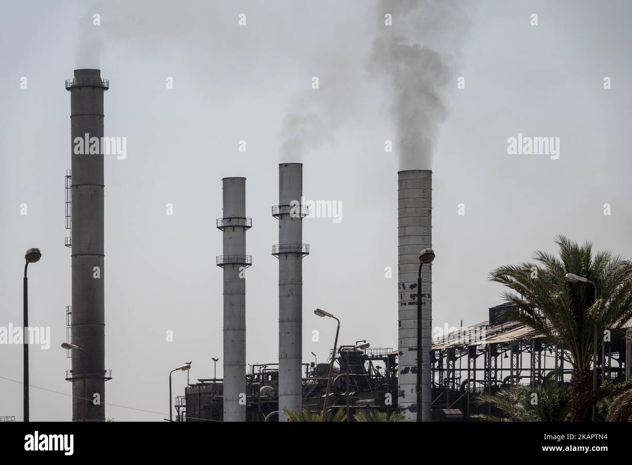 Four industrial chimneys with light smoke on the banks of the river ...
