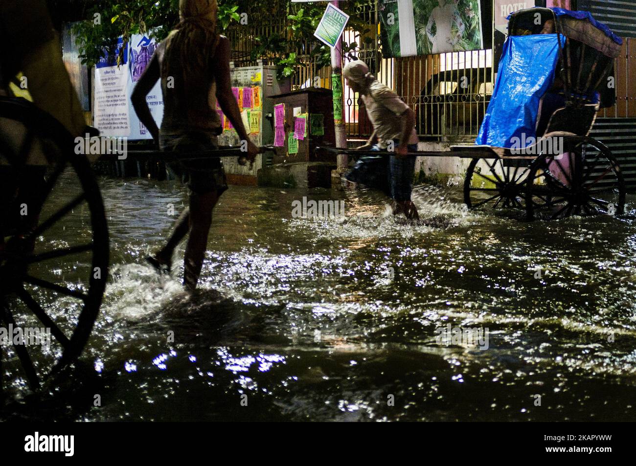 Two hand drawn rickshows are active on the street after a heavy rain at ...