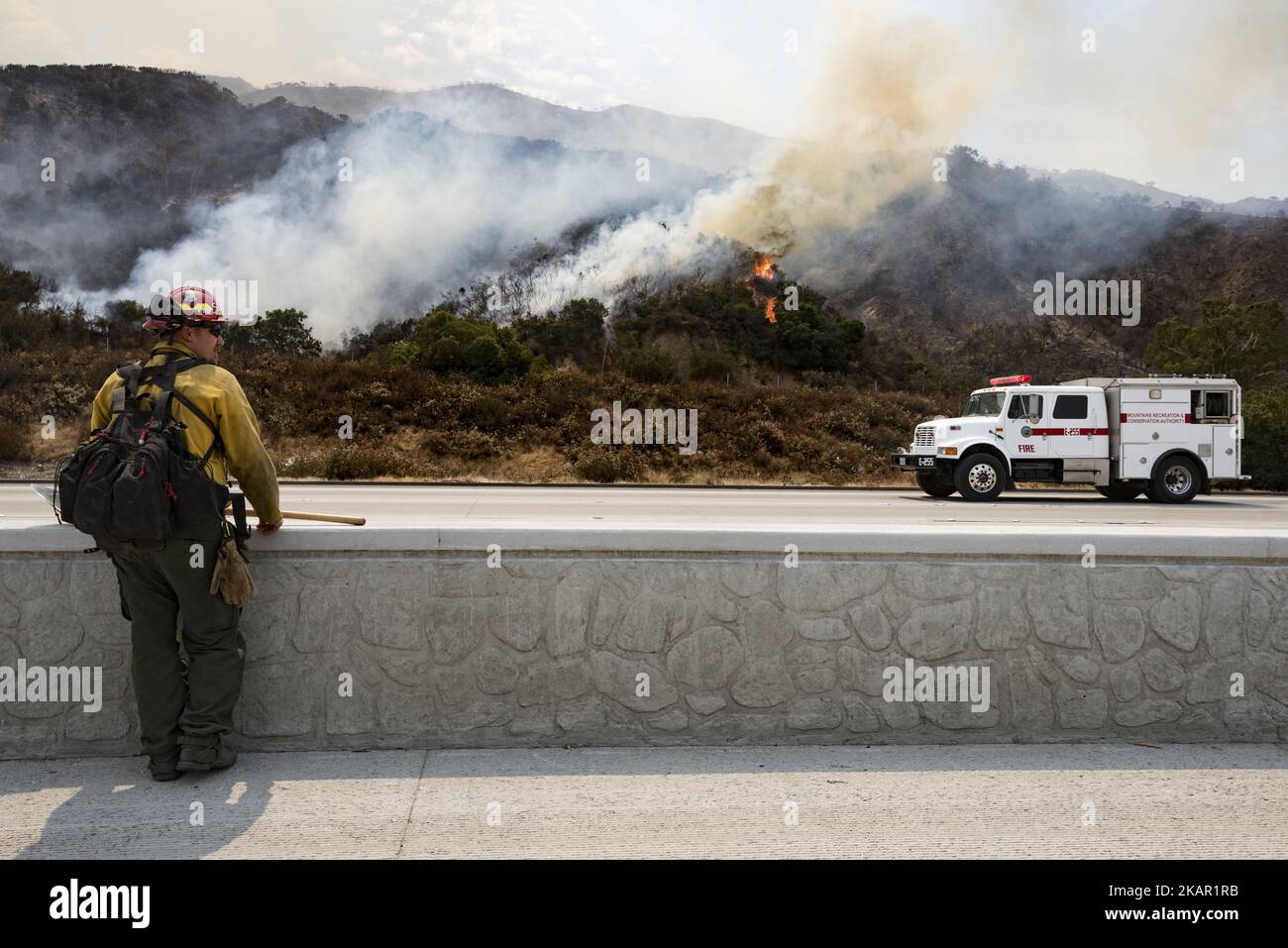 A firefighter keeps an eye on the La Tuna Canyon fire in Los Angeles ...