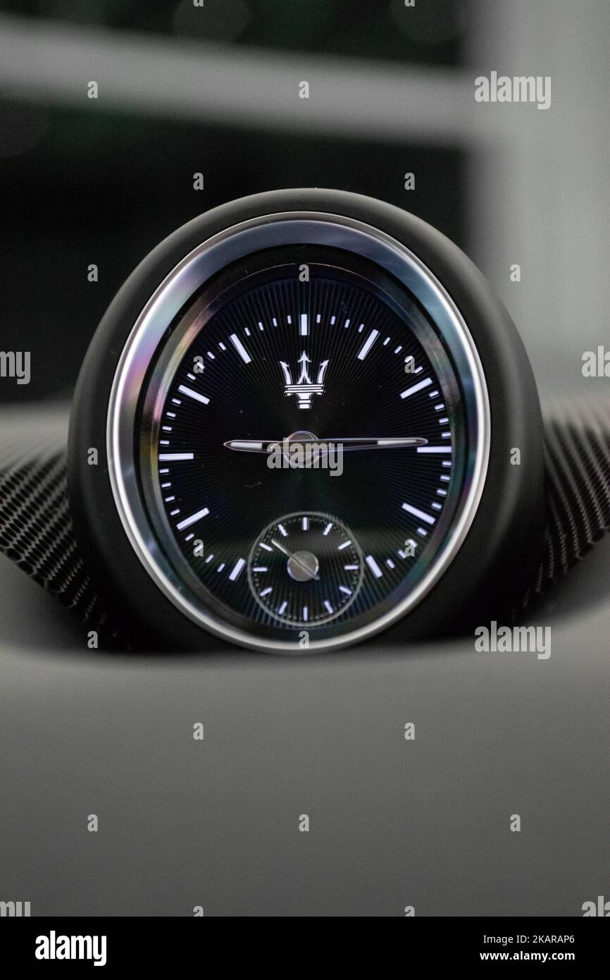 A vertical shot of a black Maserati Levante dashboard clock in a ...