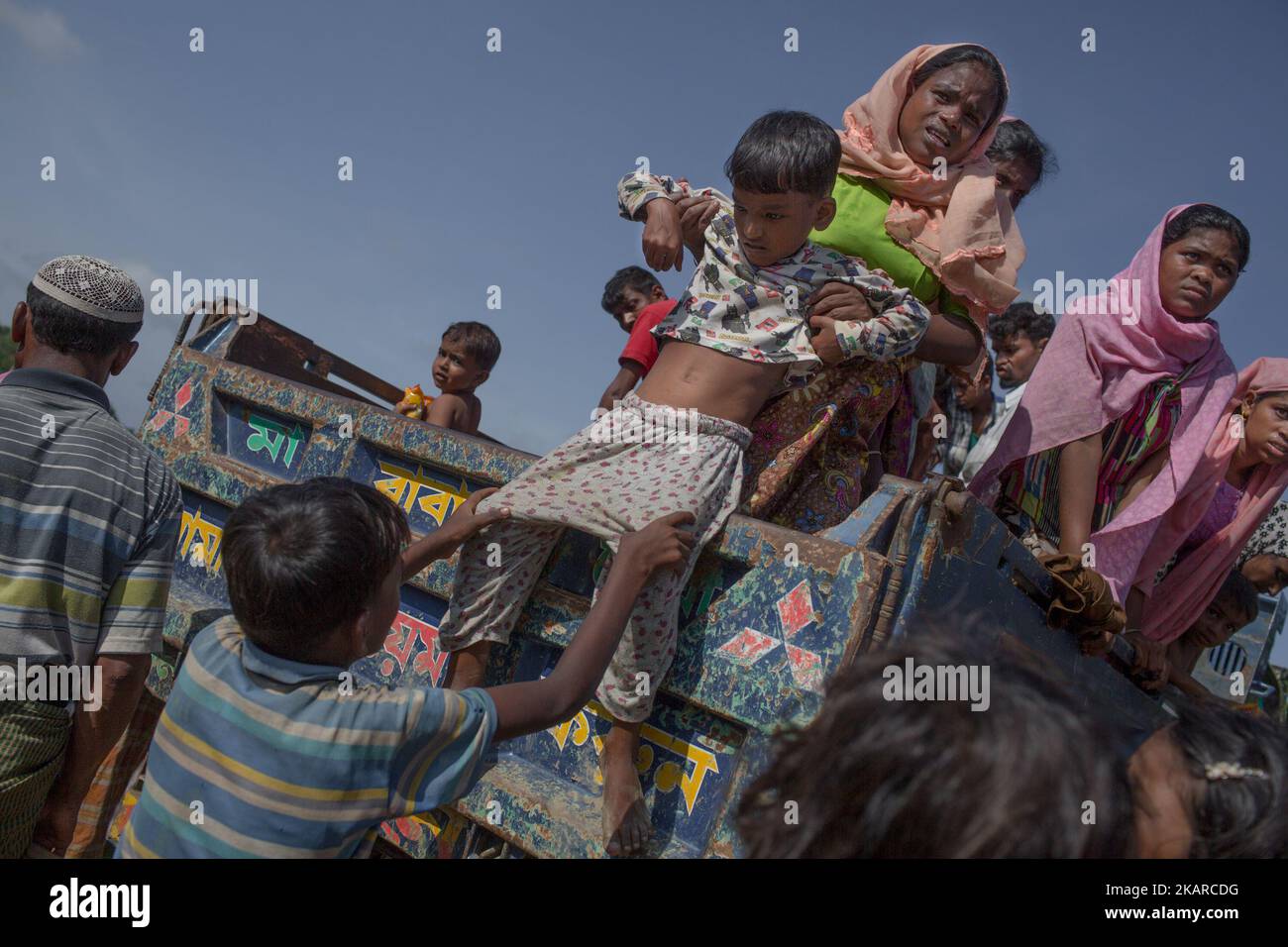 A Rohingya refugee kid is being pulled down from a truck that carried ...