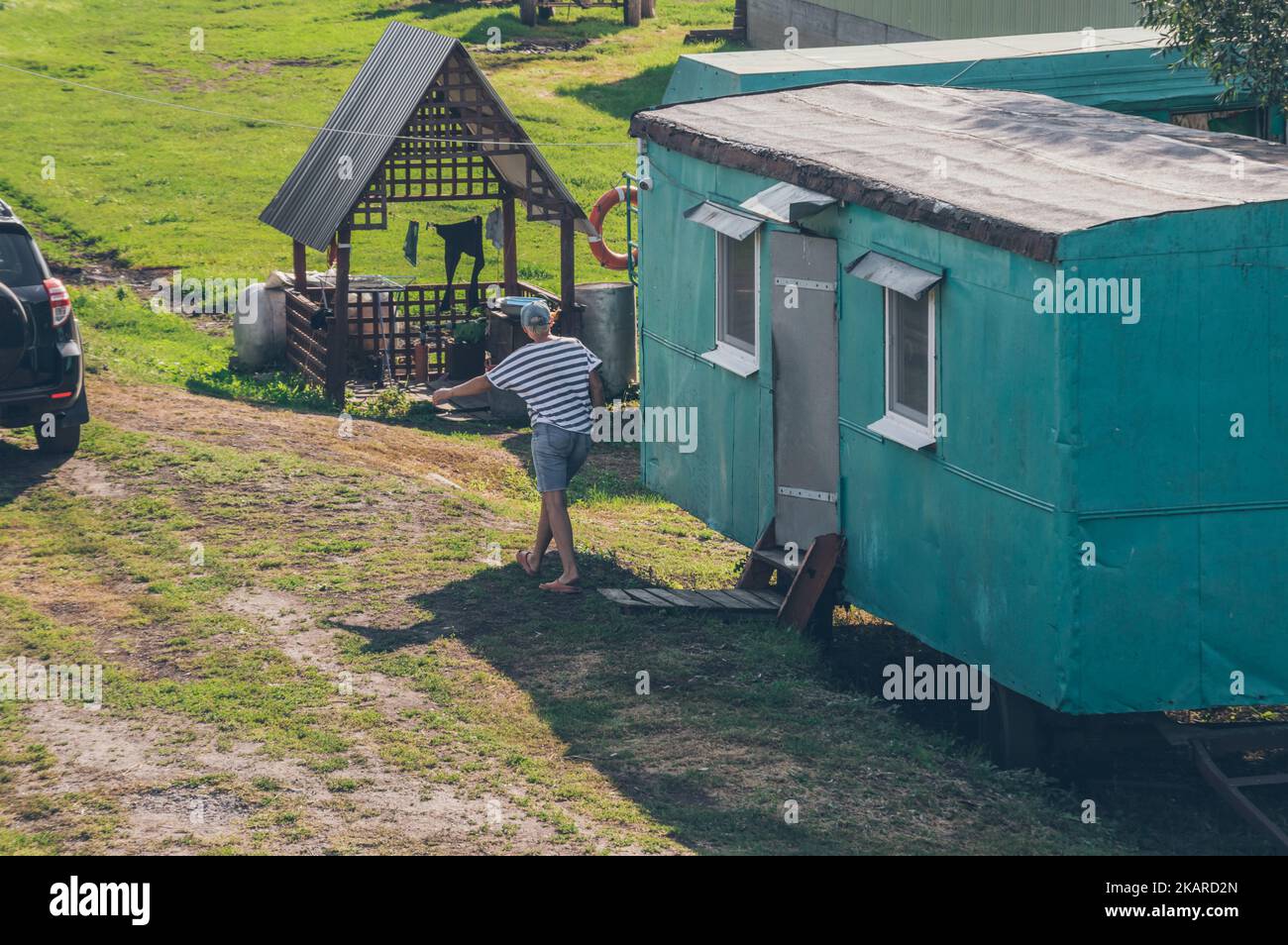 Female worker hurries past work trailer on farm, back view Stock Photo ...