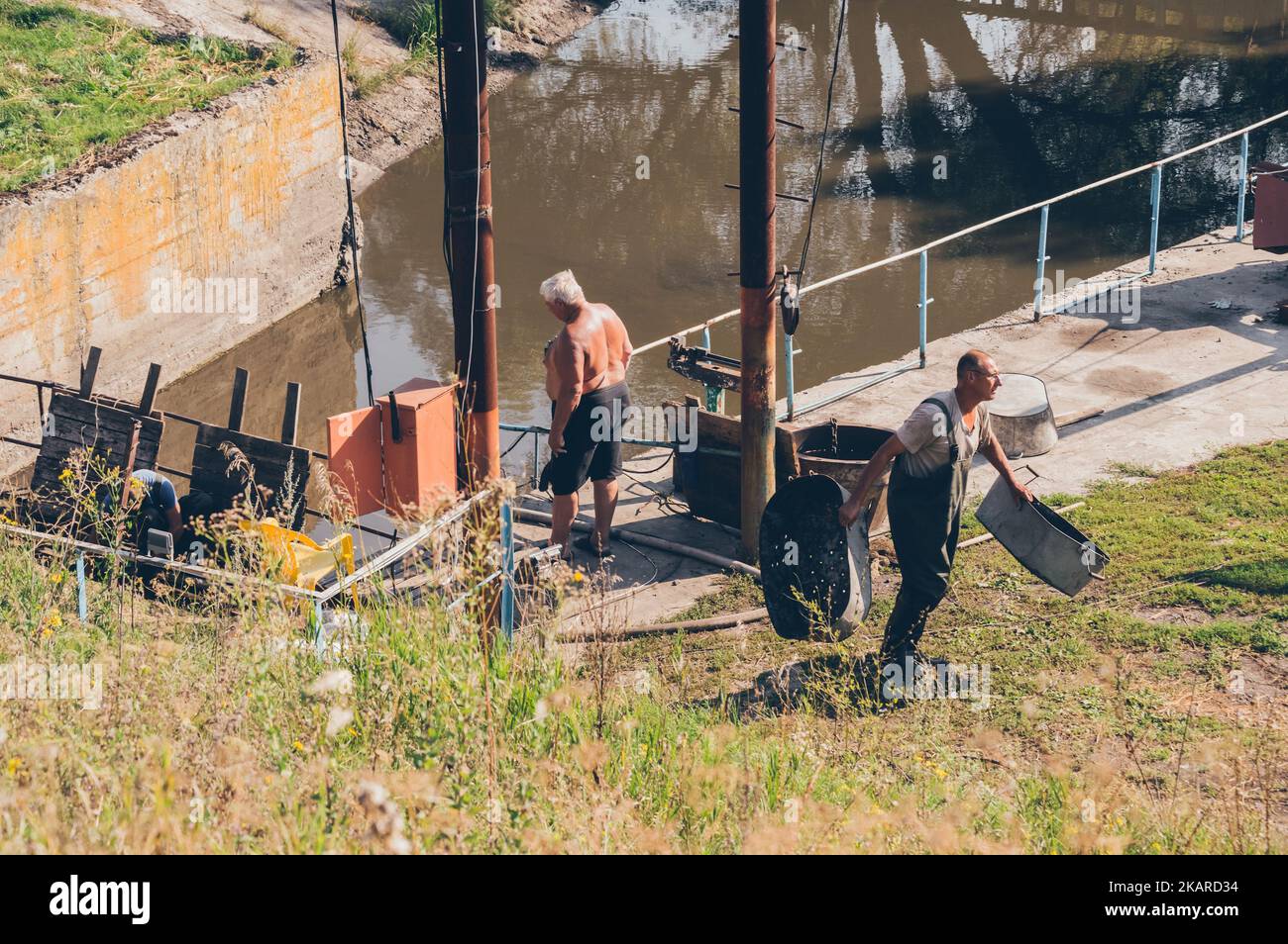 working fishermen work on shore of reservoir, top view Stock Photo - Alamy