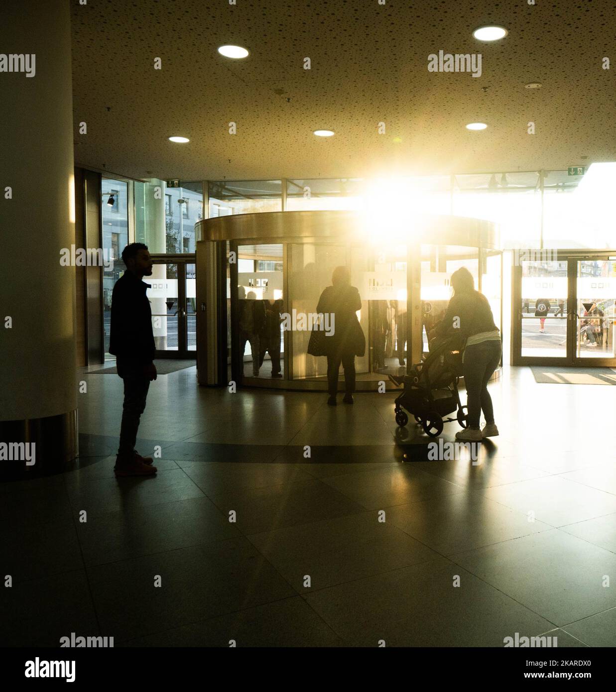 people going in and out of the mall with the sun shining Stock Photo ...