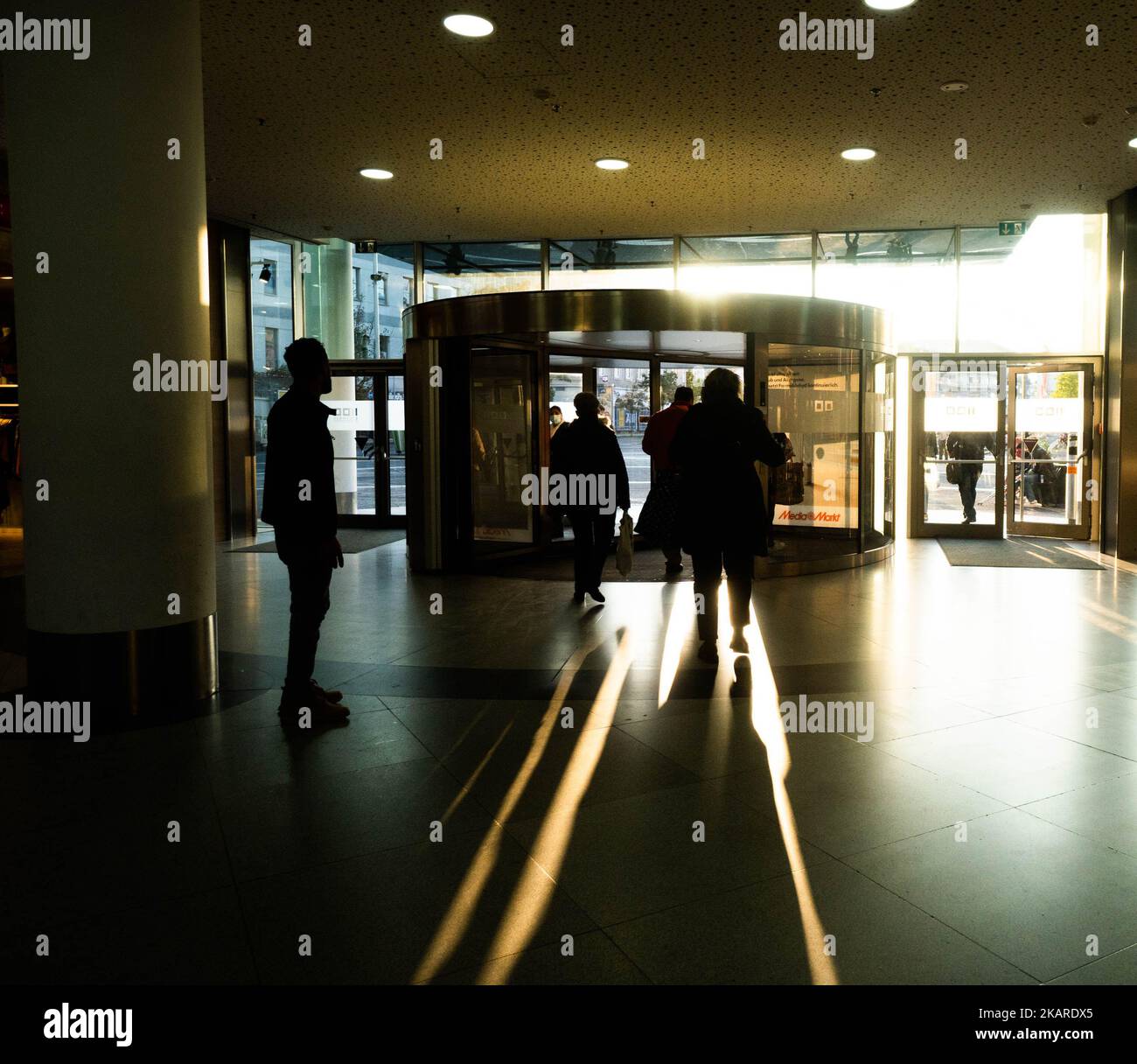 people going in and out of the mall with the sun shining Stock Photo ...