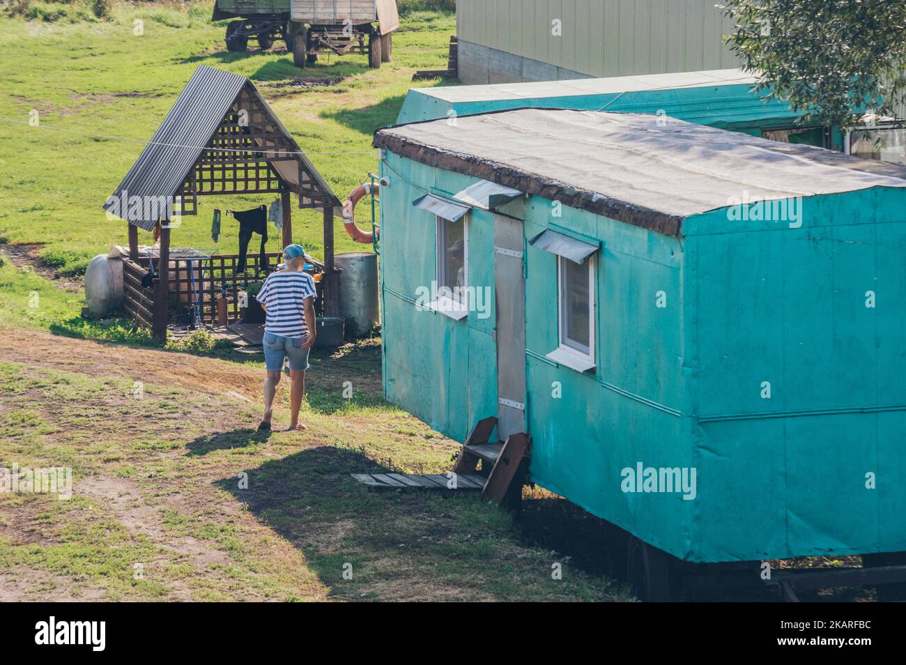 Female worker hurries past work trailer on farm, back view Stock Photo ...