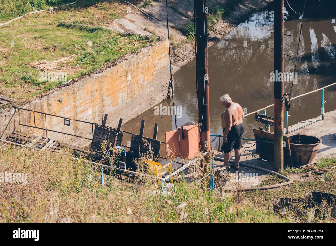 working fishermen work on shore of reservoir, top view Stock Photo - Alamy