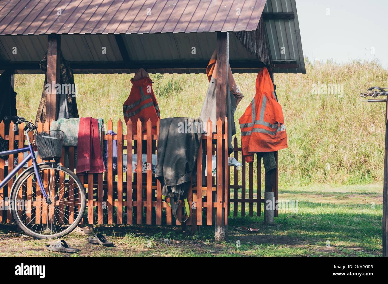 work clothes and bicycle at picket fence of gazebo in open air Stock ...