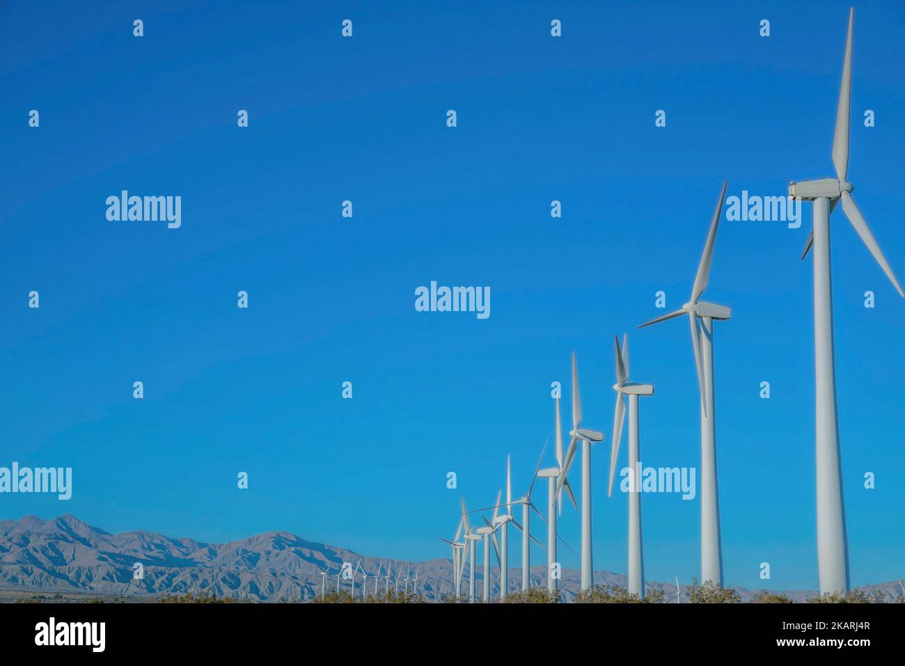 Wind turbines with tubular steel tower on a desert in California. There ...