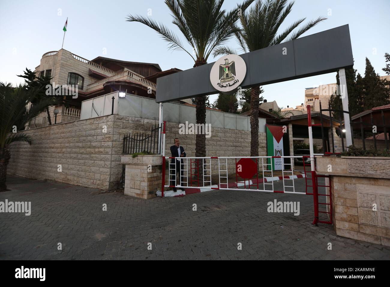 Palestinians walk past the entrance to the Palestinian cabinet ...