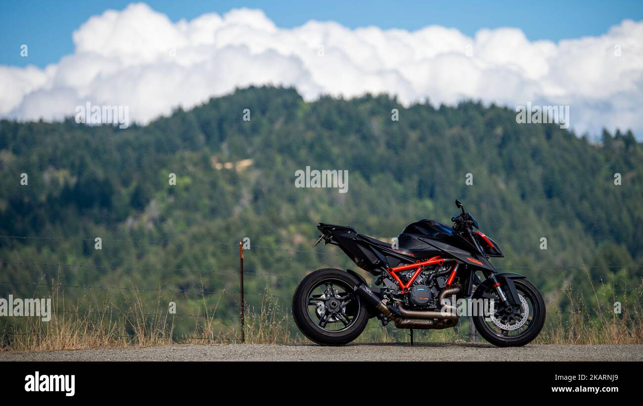 The KTM 1290 Super Duke R parked on side of mountain road with trees ...