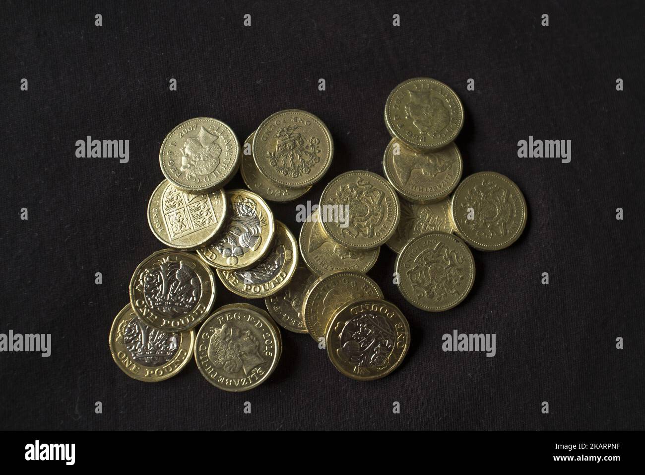 The old £1 coins are pictured alongside the new 12-sided one pound ...