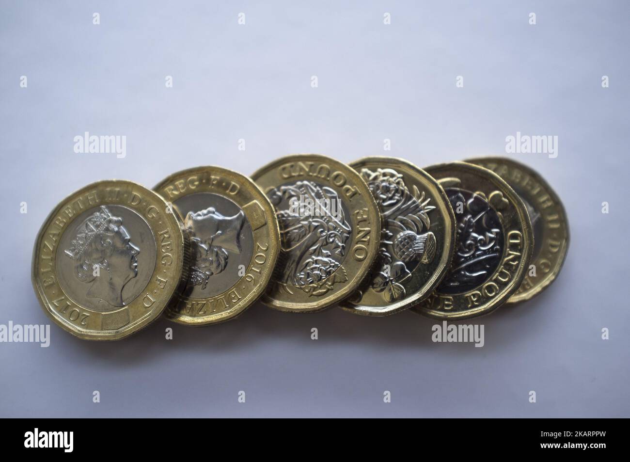 The old £1 coins are pictured alongside the new 12-sided one pound ...
