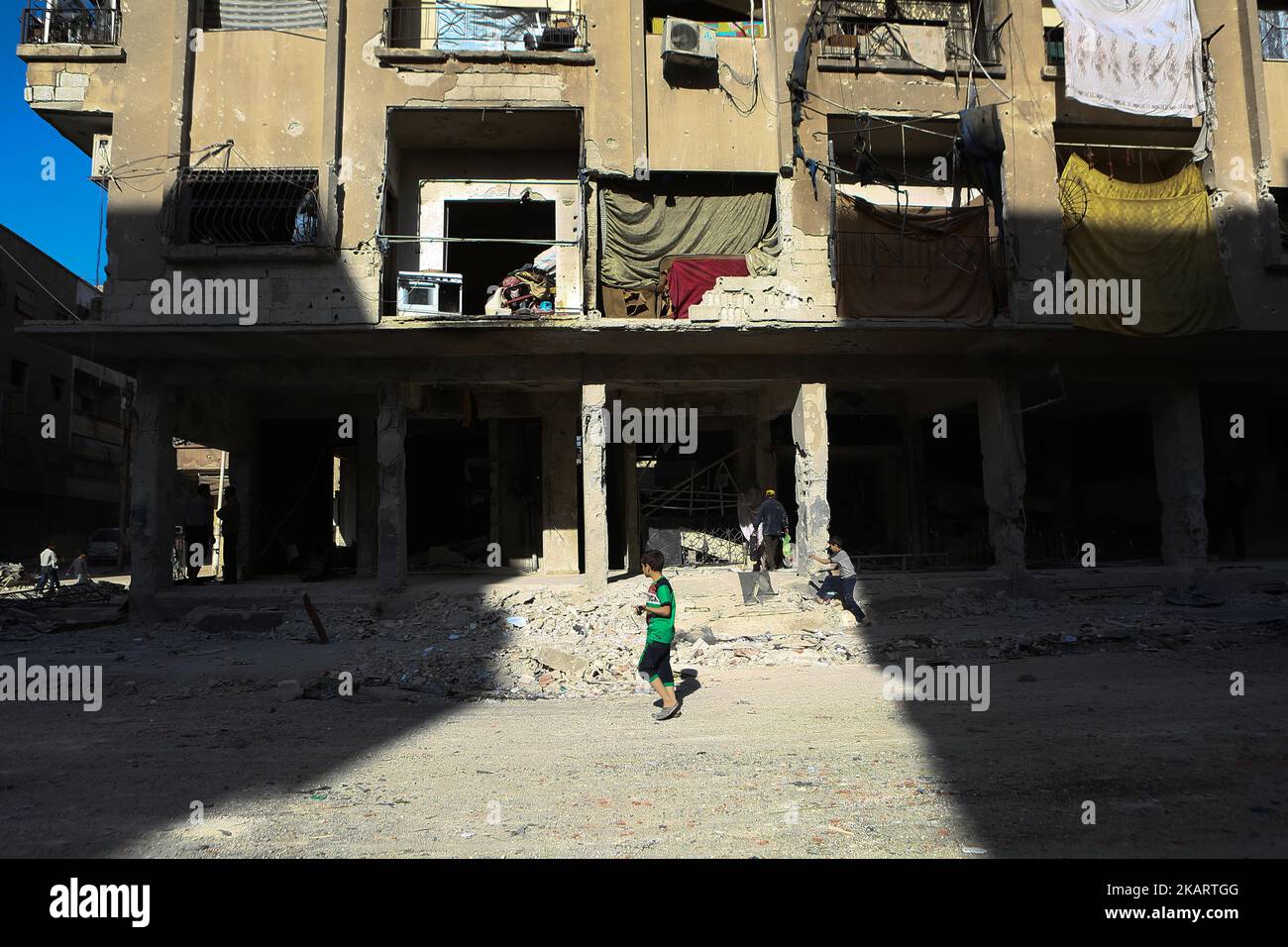 A child walks beside destruction rubble of a building in the rebel ...