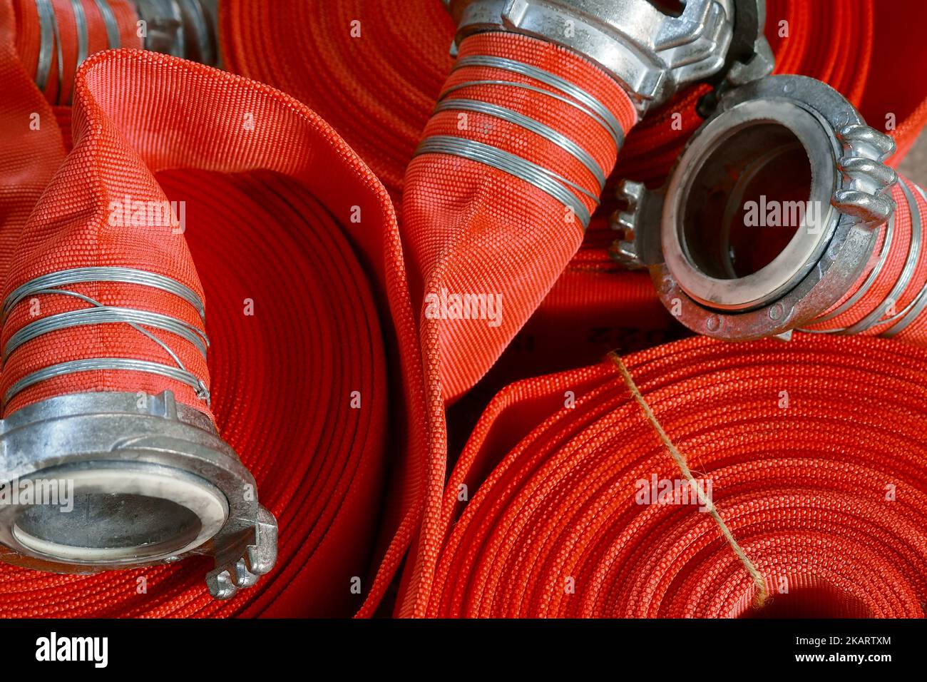 View of many twisted red fire hoses close-up in full screen. New fire ...