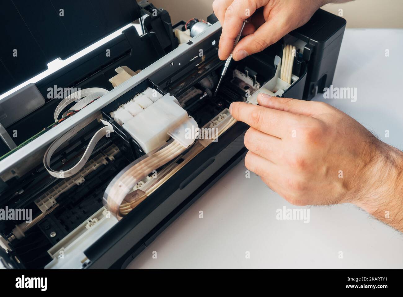 Maintenance and repair of printers. Master's hands with screwdriver ...