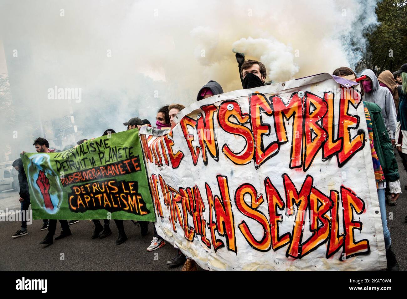 People march behind a banner as thousands gather in the streets of Lyon ...