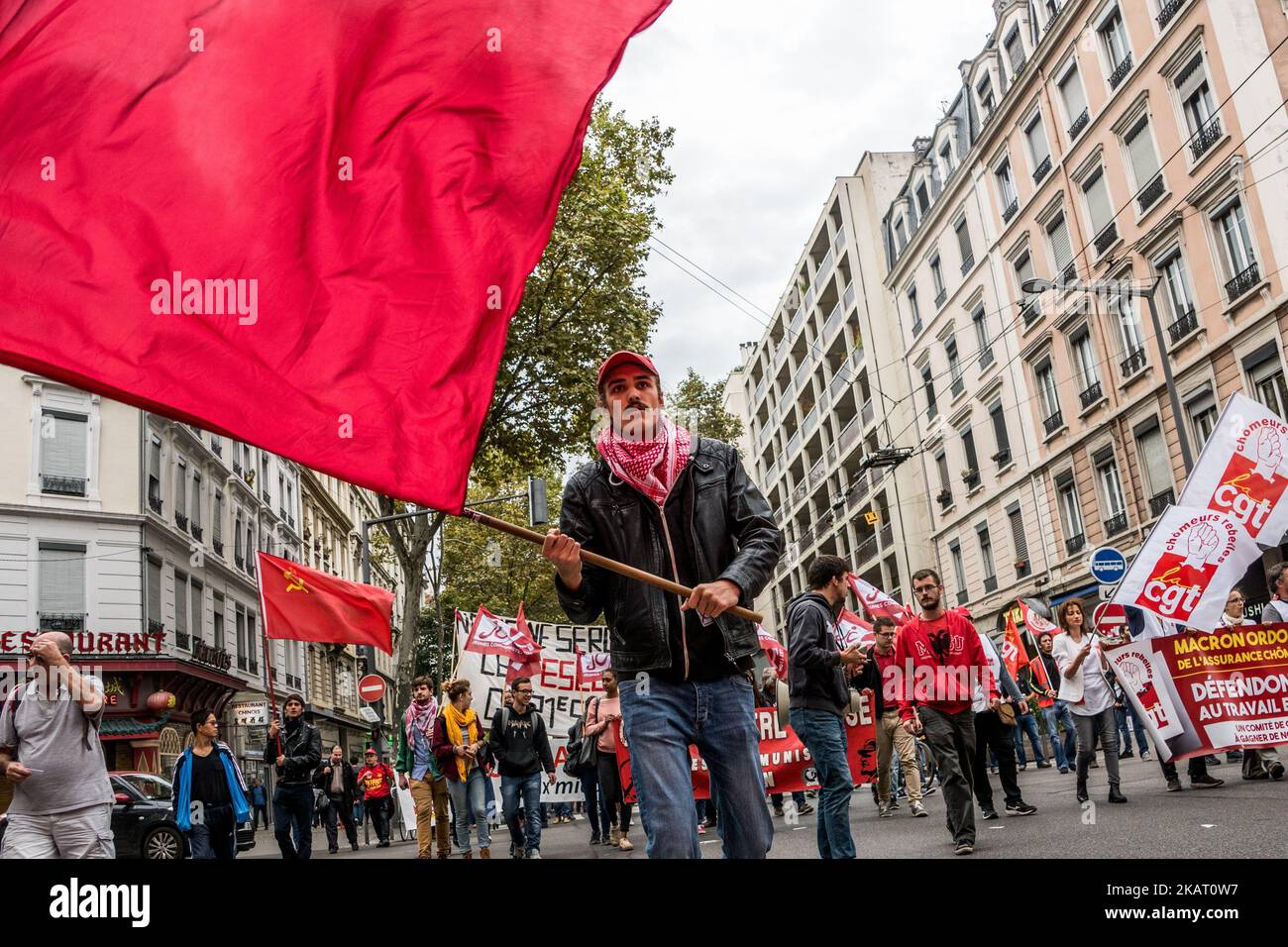 People march behind a banner as thousands gather in the streets of Lyon ...