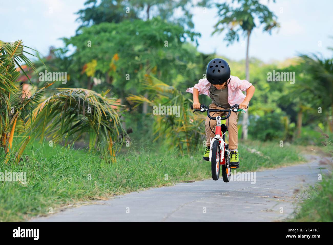 Country cycling walk. Young rider kid in helmet and sunglasses riding ...