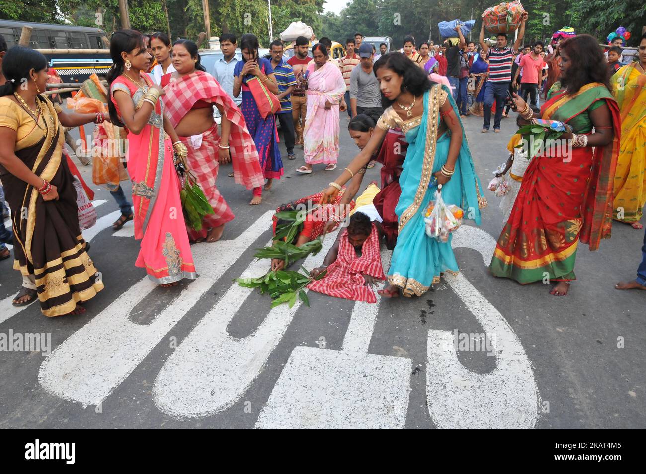 A Indian woman lying prostrate worshiping the Sun god during Chhat puja ...