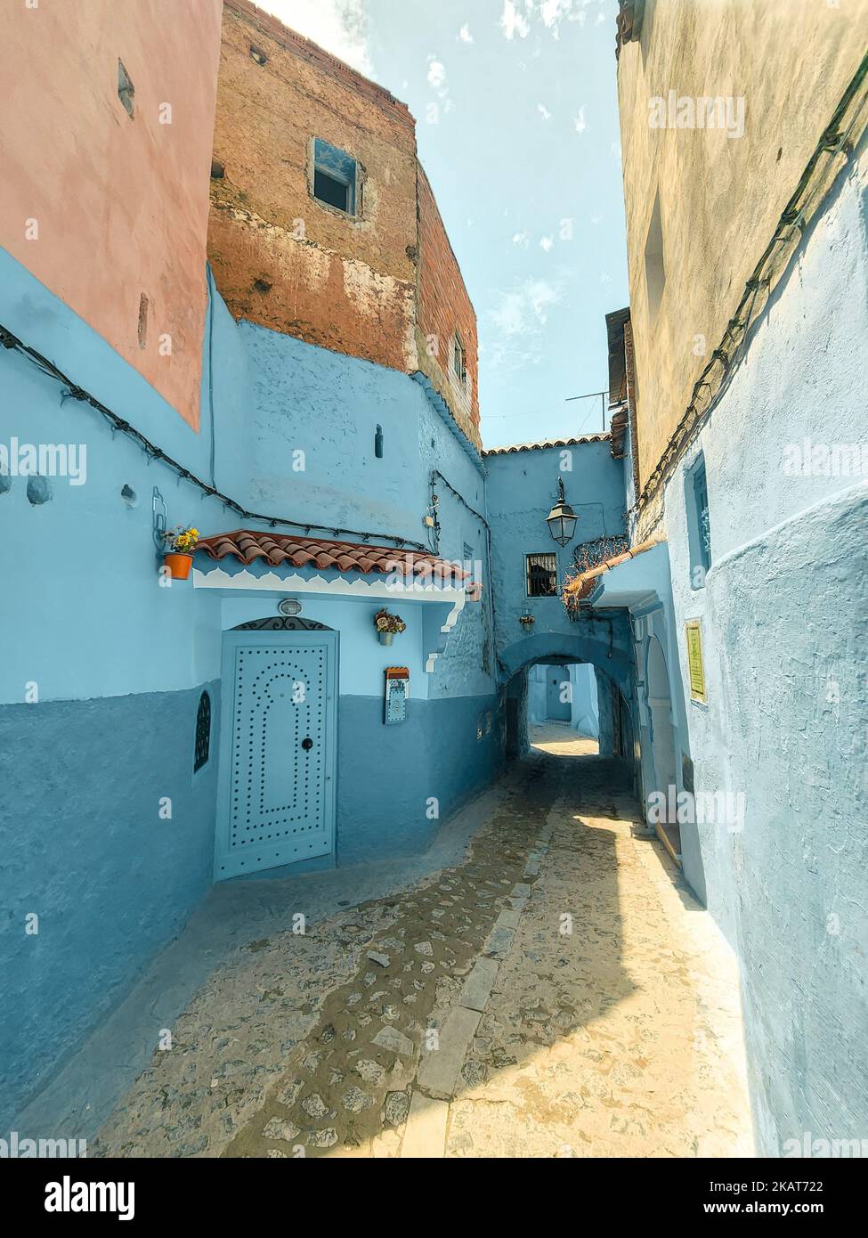 A narrow alley between beautiful blue-washed buildings in Chefchaouen ...