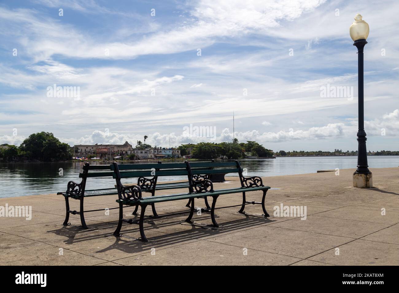 A pair of dark green wooden benches against each other on the promenade ...