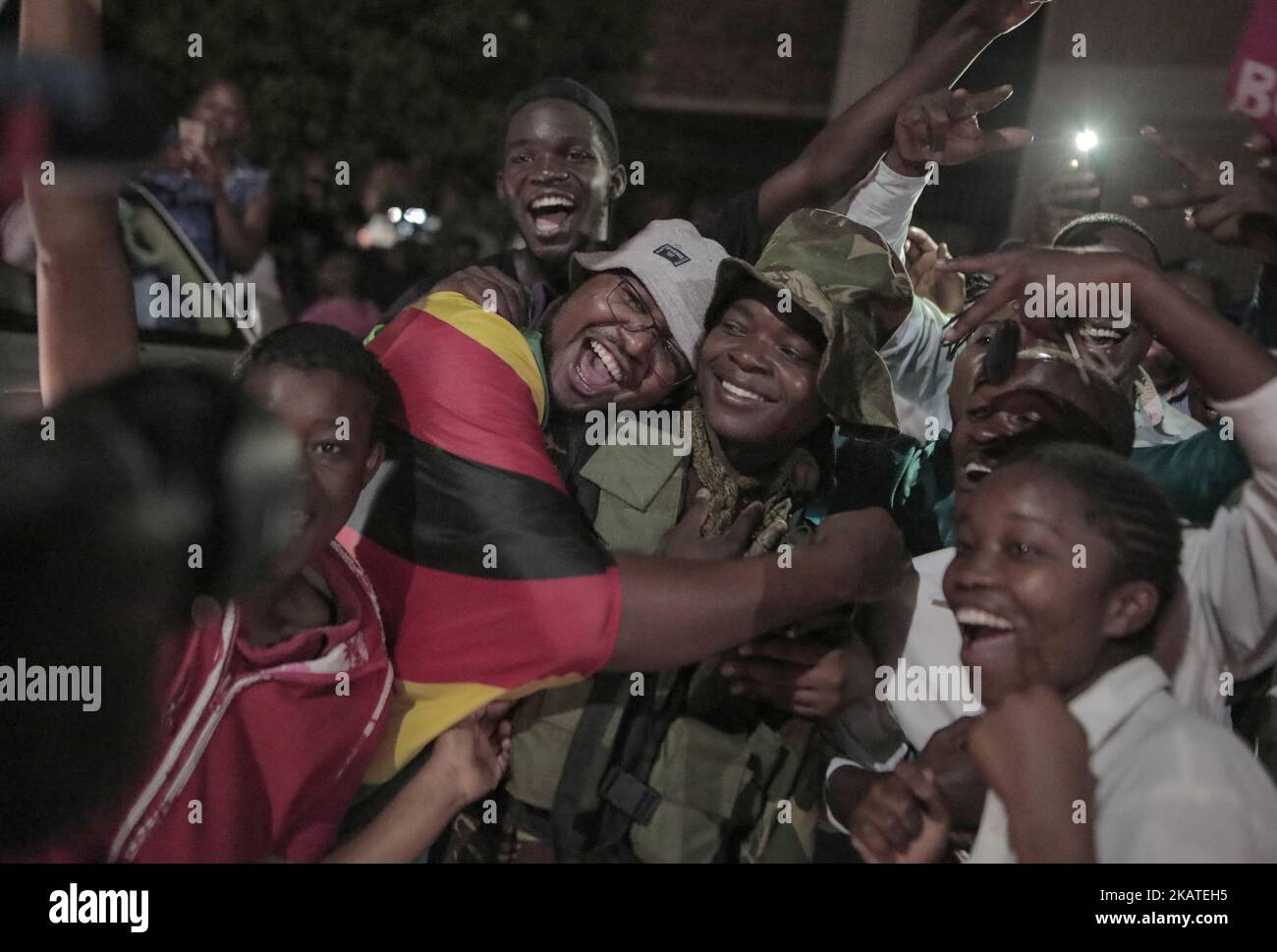 Zimbabweans drink, sing, and dance as they celebrate at night at an ...