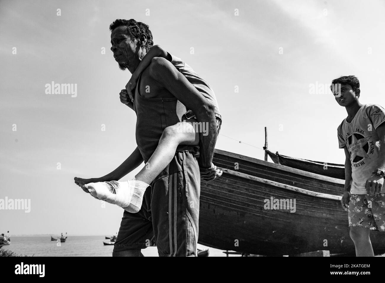 A newly arrived Rohingya refugee man carries her child after arriving ...