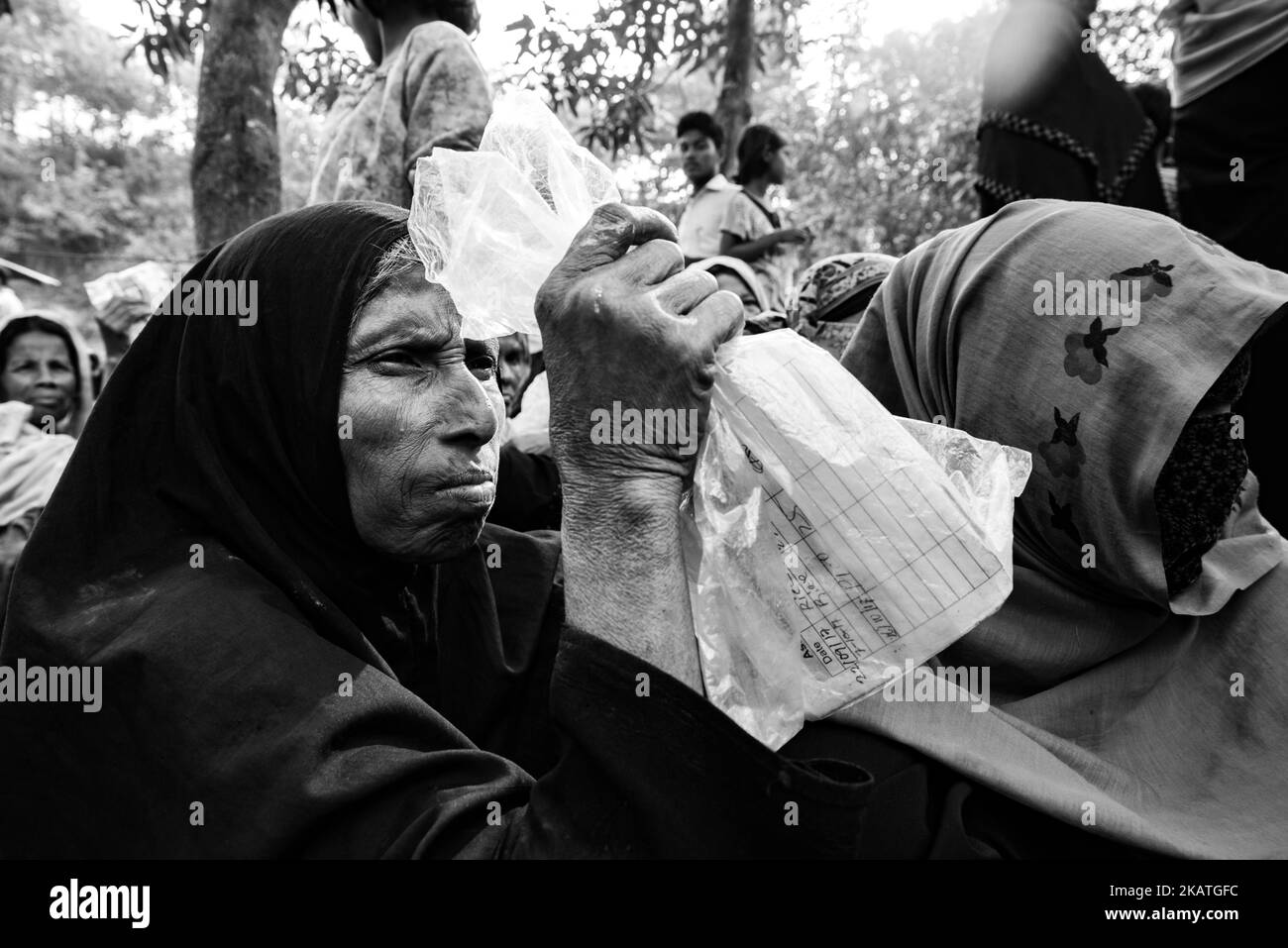 A Rohingya refugee old woman wait to receive food aid from a local NGO ...