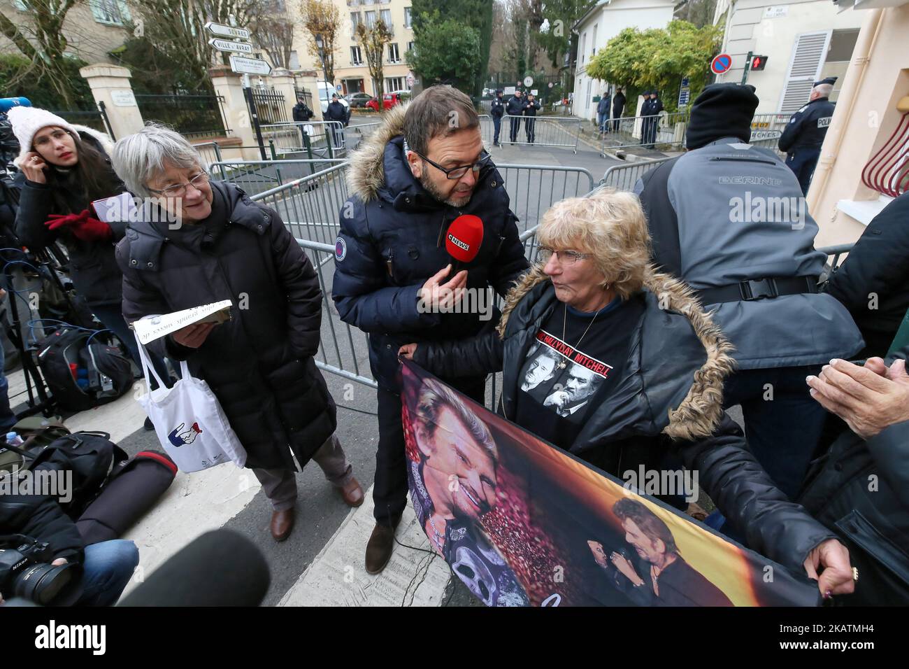 A fan of French singer and actor Johnny Hallyday holds a portrait of ...