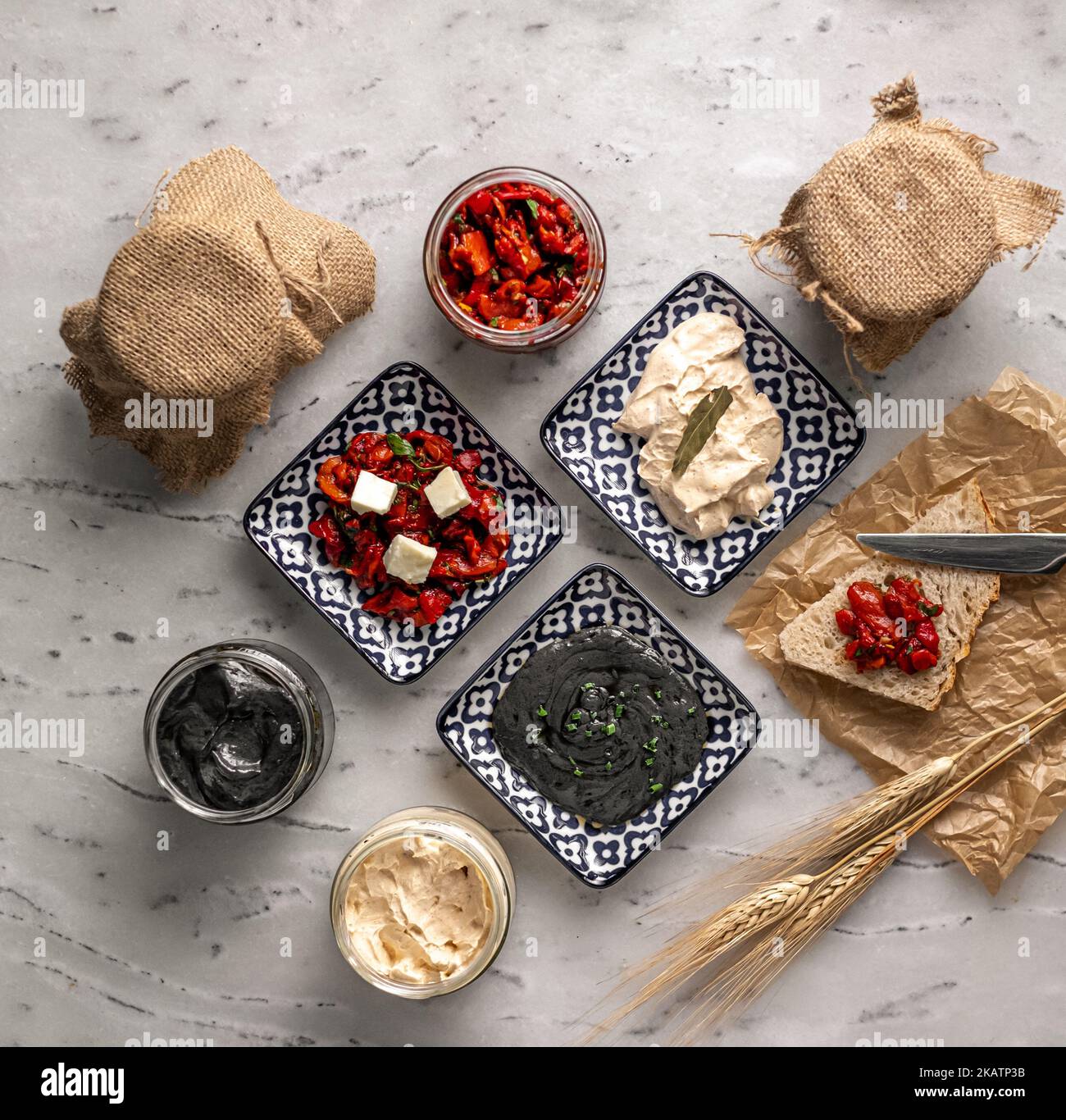 A top view of dishes in plates and jars on a white marble table Stock ...
