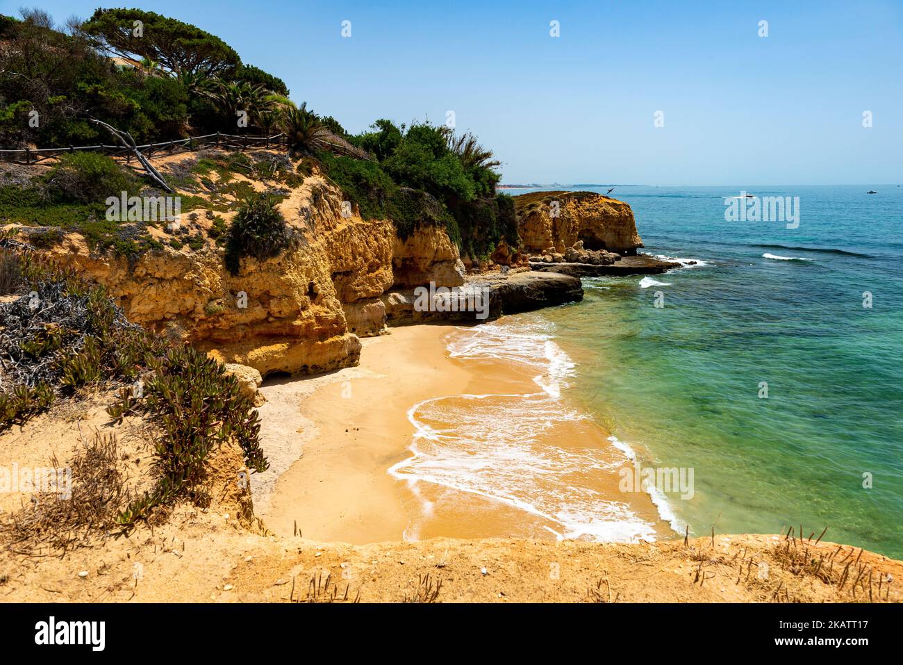 An aerial shot of a beach with cliffs and stones and waves washing the ...