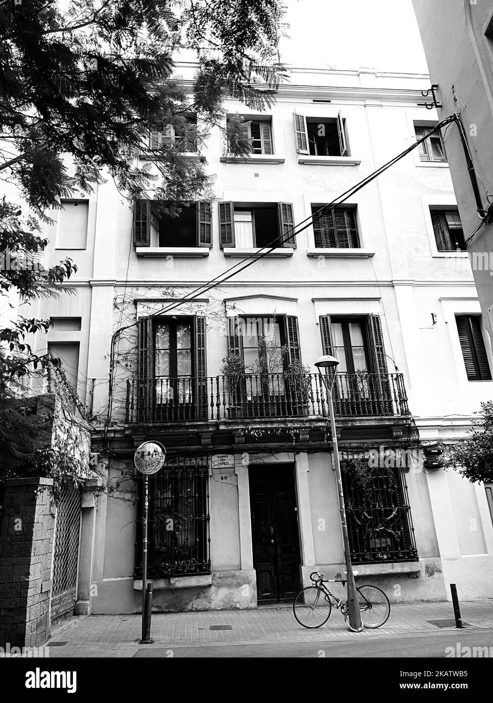 A grayscale of a building with old architecture and a bike in front ...