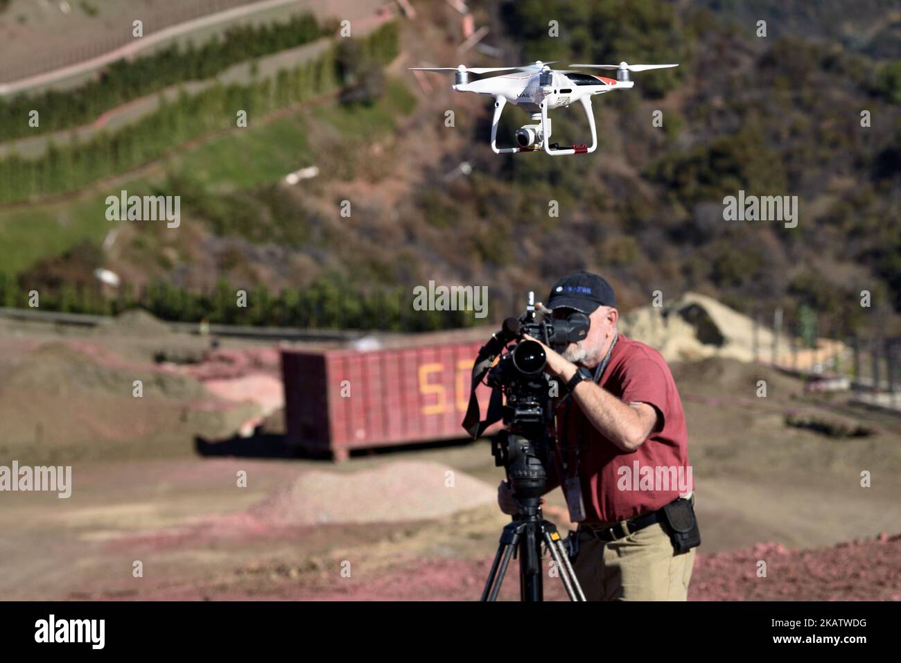 A news cameraman takes a video of a drone flying during a demonstration ...