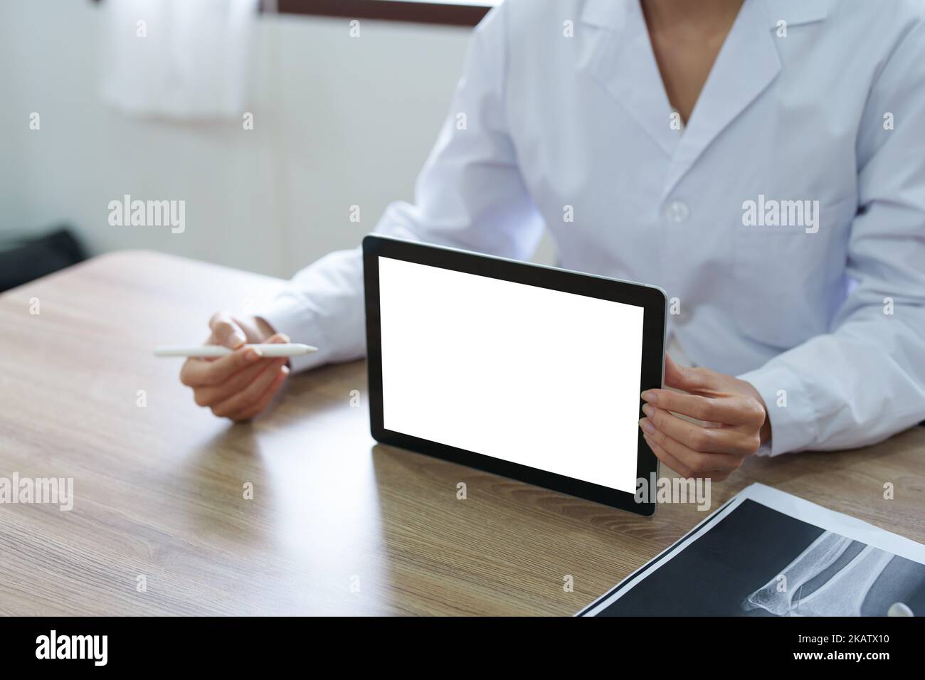 Asian female doctor holds computer tablet to customer, white screen can ...