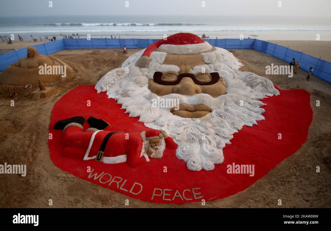 A sand portrait of Santa Claus is seen on the Bay of Bengal Sea's ...